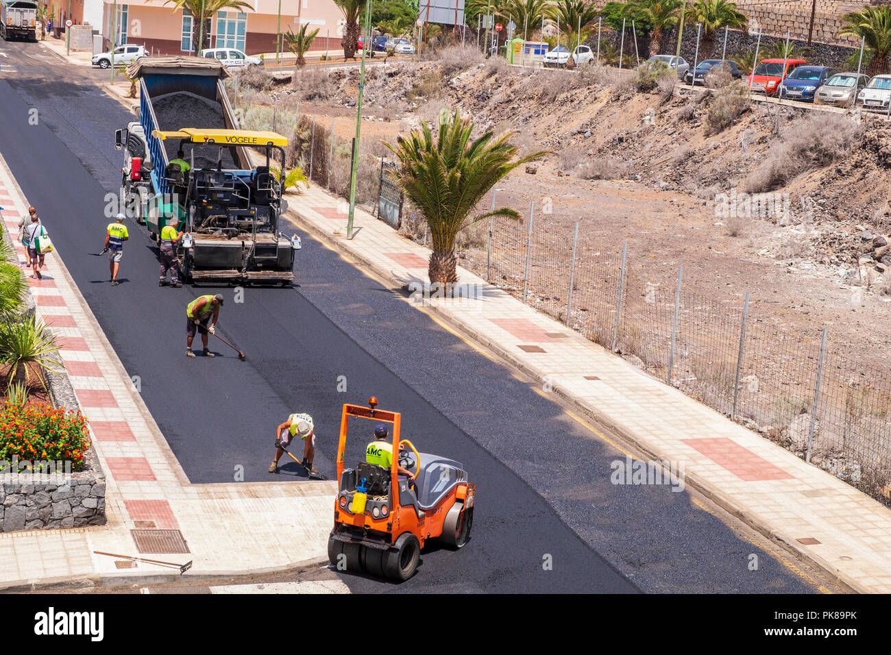 Asphalt spreading machine laying down a new layer of tarmac on the road ...