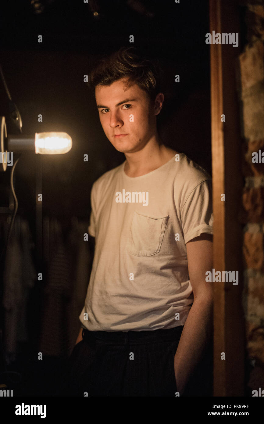 Portrait of a fashion designer in his dressing room, illuminated by a ...