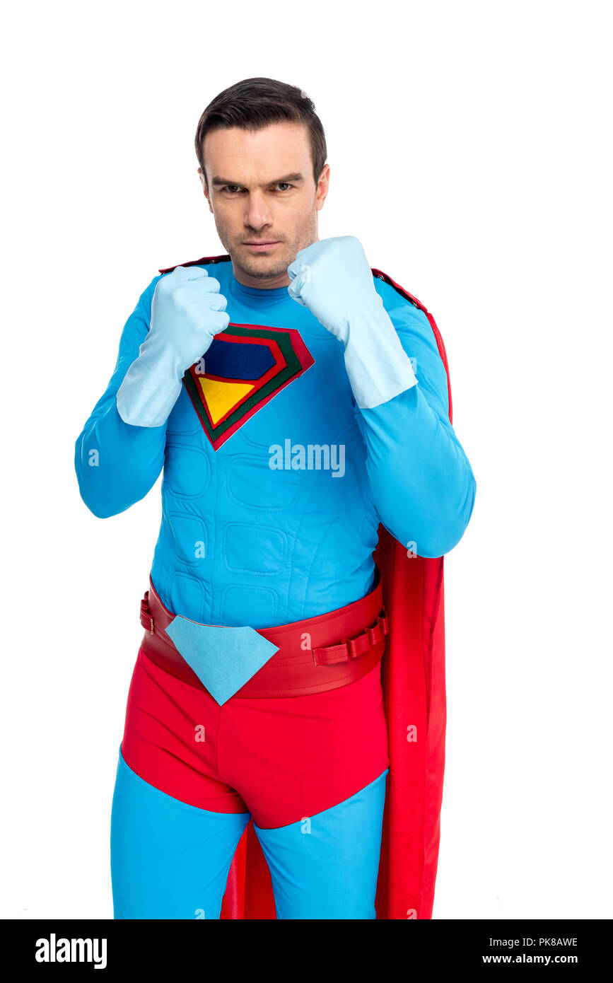 serious male superhero in rubber gloves standing with fighting position ...