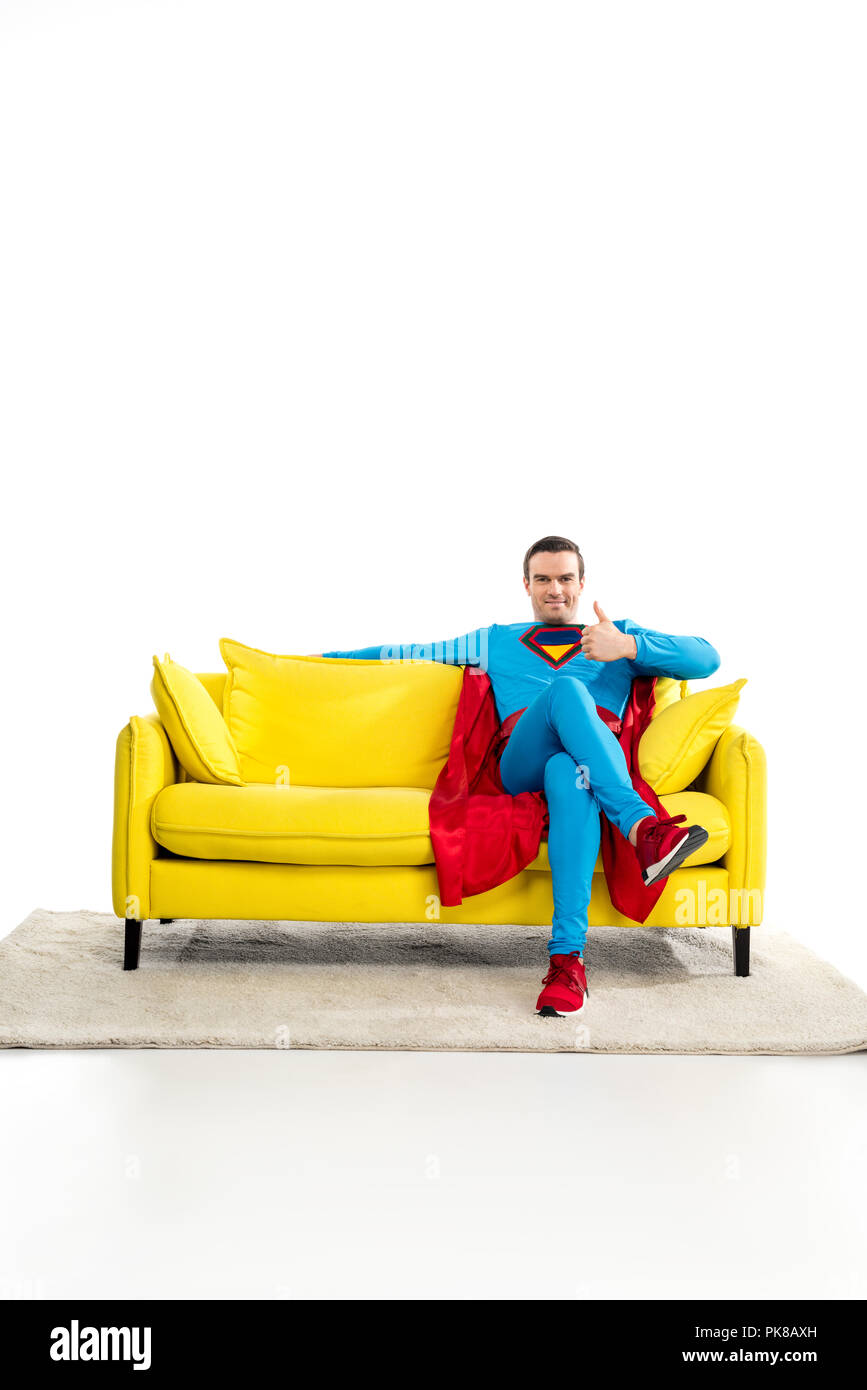 handsome male superhero sitting on couch and showing thumb up on white ...