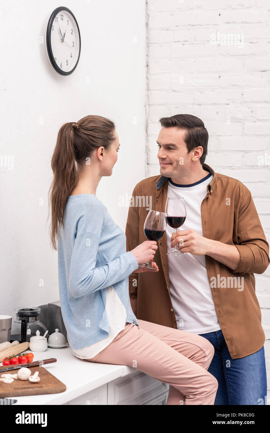beautiful adult couple clinking glasses of champagne on kitchen Stock Photo - Alamy