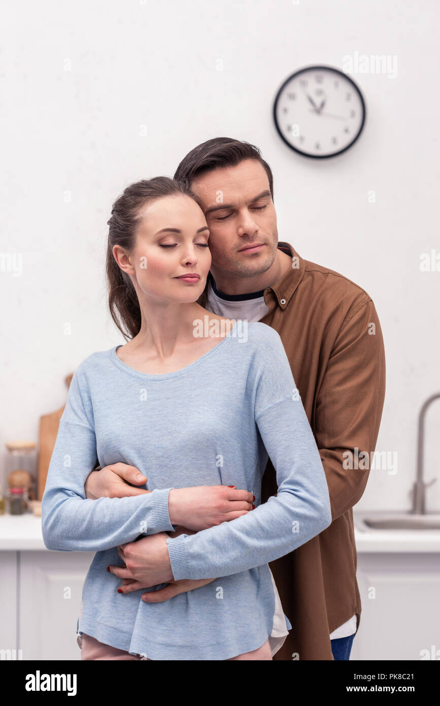 happy adult couple embracing at kitchen Stock Photo - Alamy