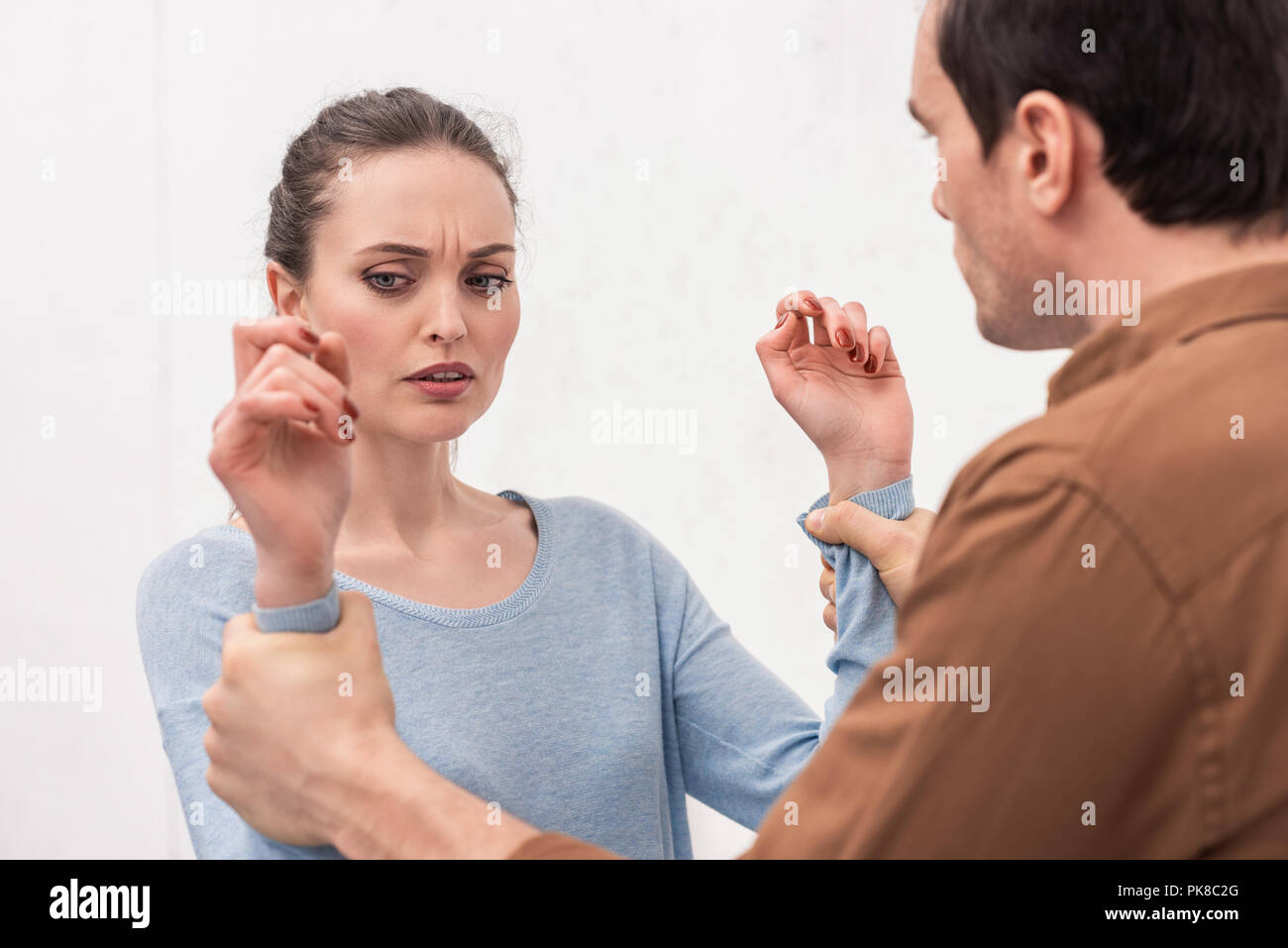 angry man holding hands of woman during argument Stock Photo - Alamy