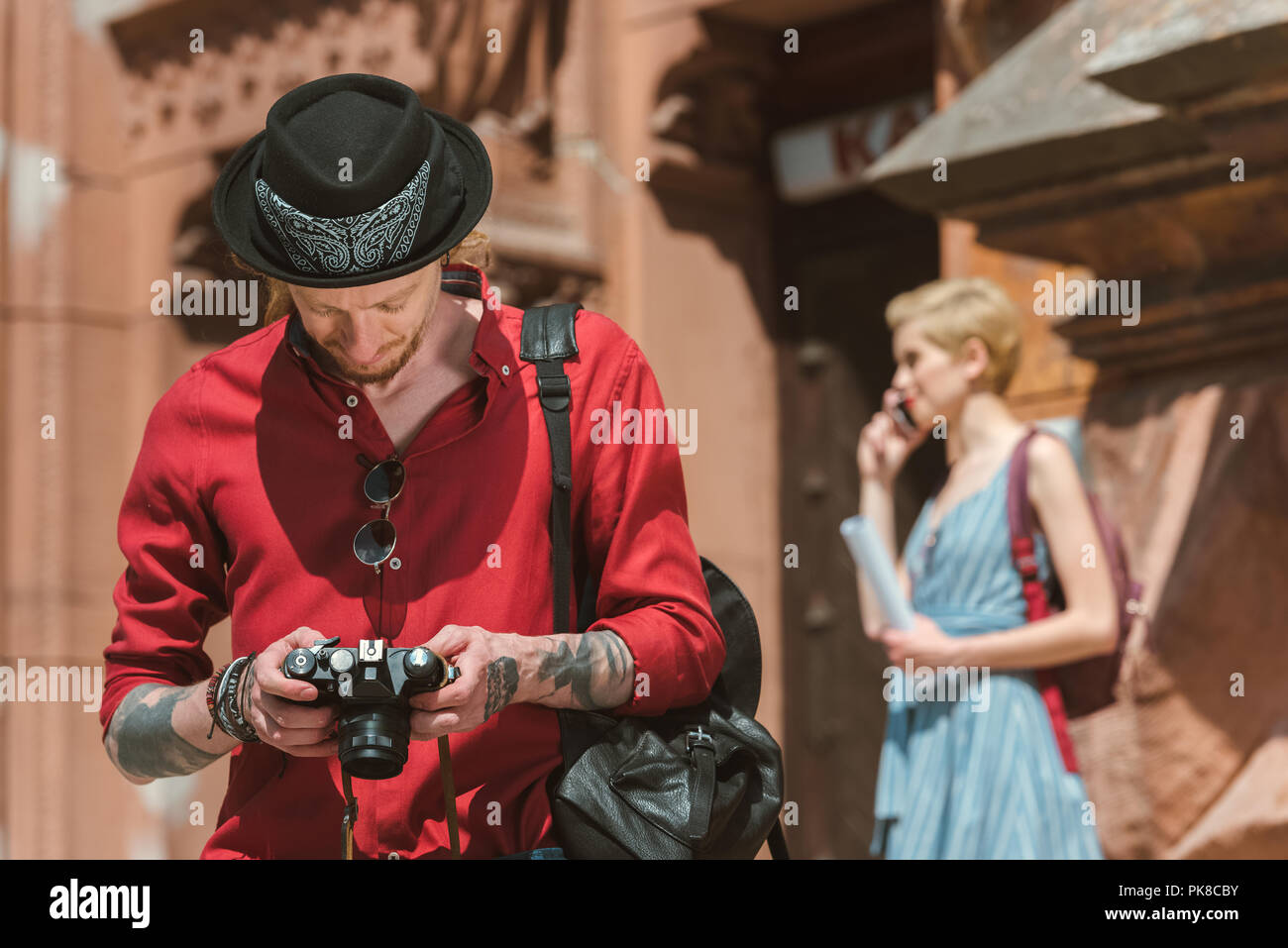 man looking at photo camera while girlfriend standing behind Stock ...