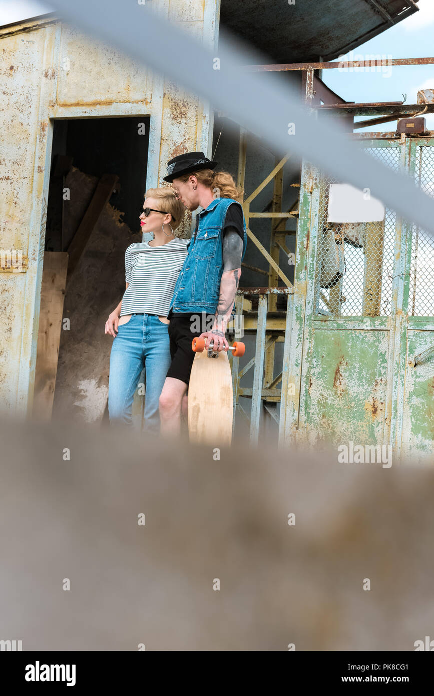 view through fence on boyfriend with tattoos and stylish girlfriend ...