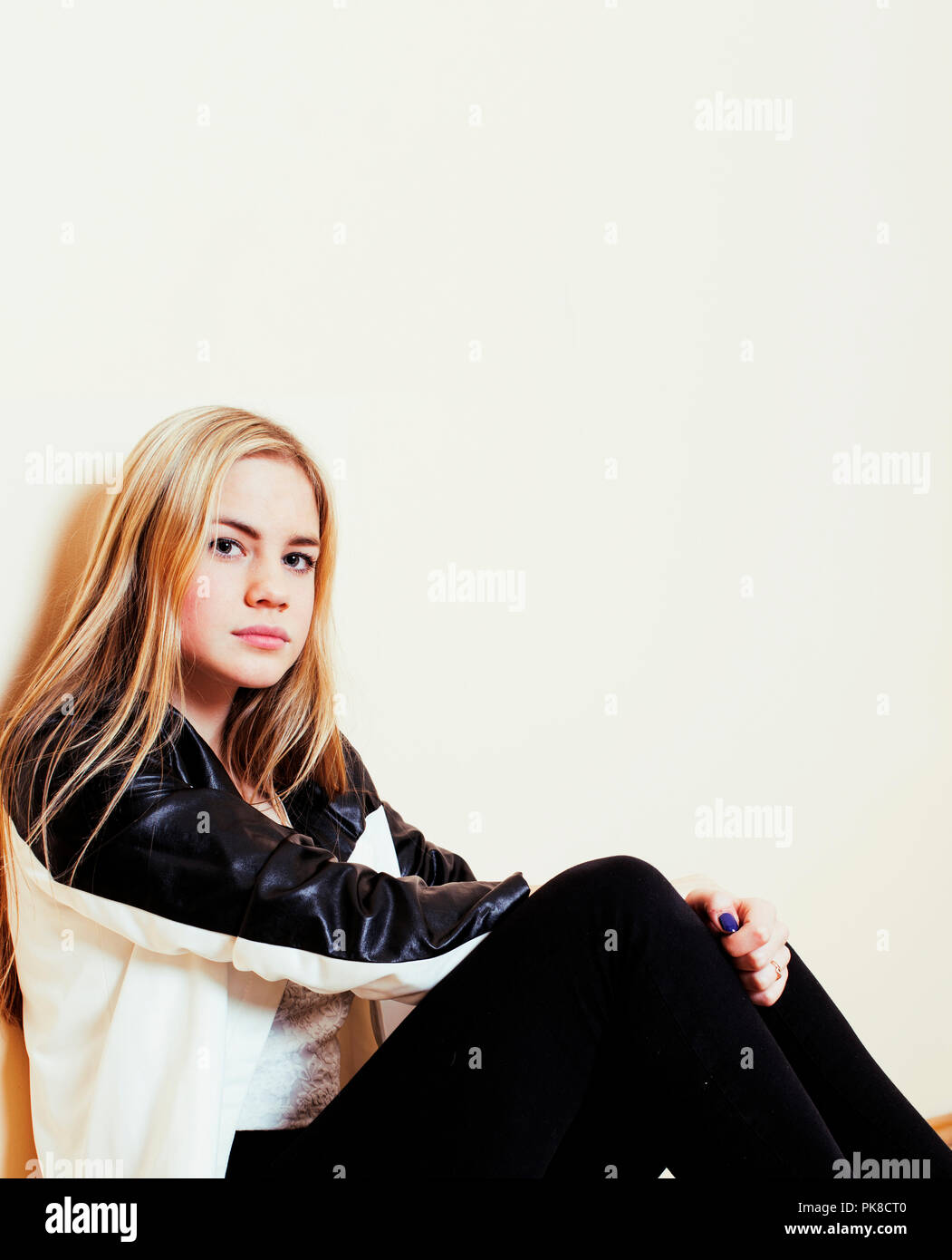 young pretty teenage blond girl sitting on floor at home despair Stock ...