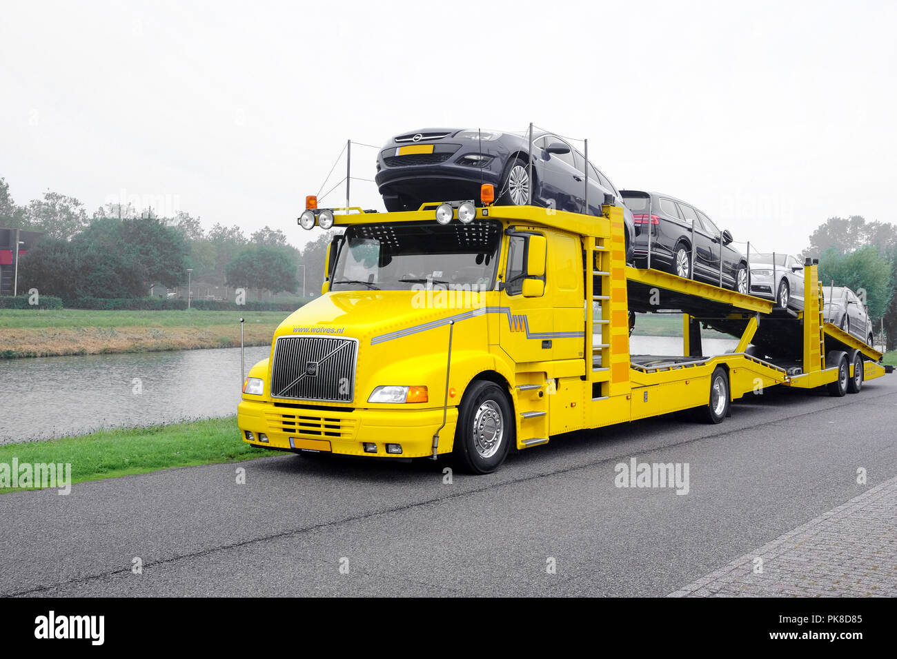 yellow car transporter with various cars on the loading floor Stock ...