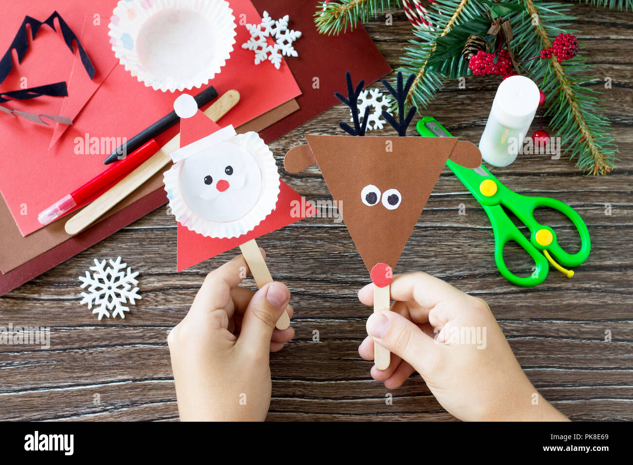 A child is holding Christmas Santa and Reindeer stics puppets. Handmade ...