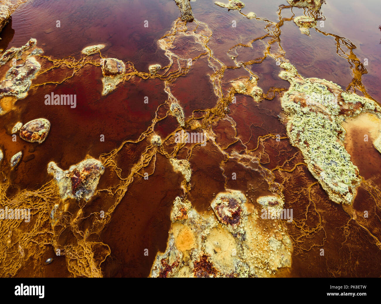 Stones in the red waters of Riotinto connected by stromatolites, this ...