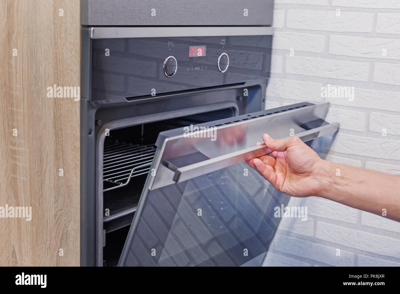 Man hand open electric oven, close up photo Stock Photo - Alamy