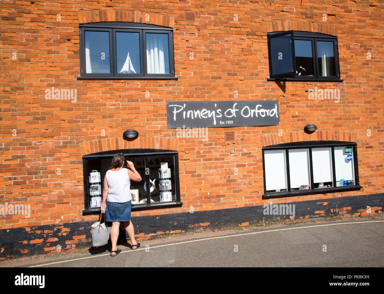Pinney's of Orford woman looking into shop window, Orford, Suffolk ...