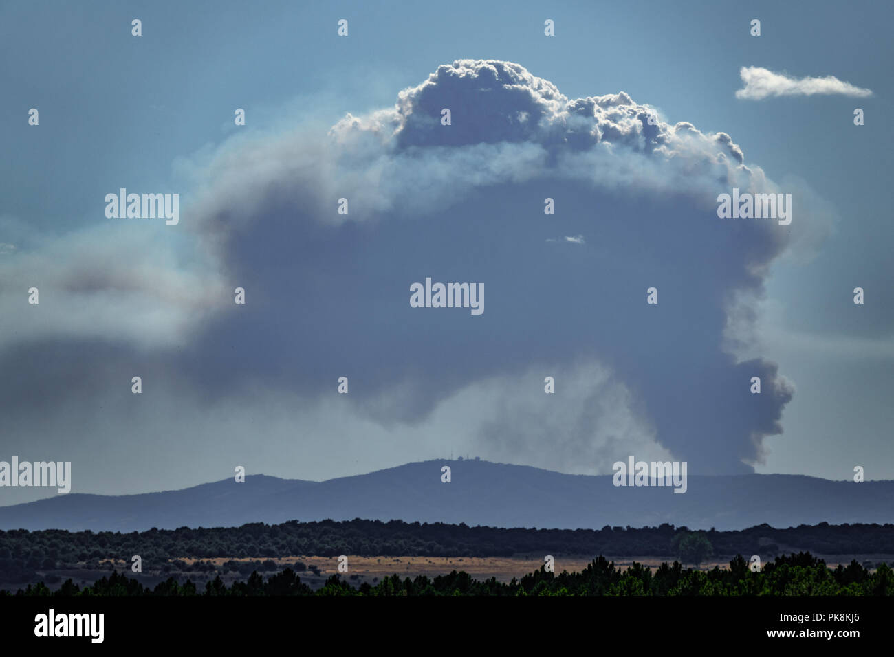 Huge fire in the long distance behind mountains Stock Photo - Alamy