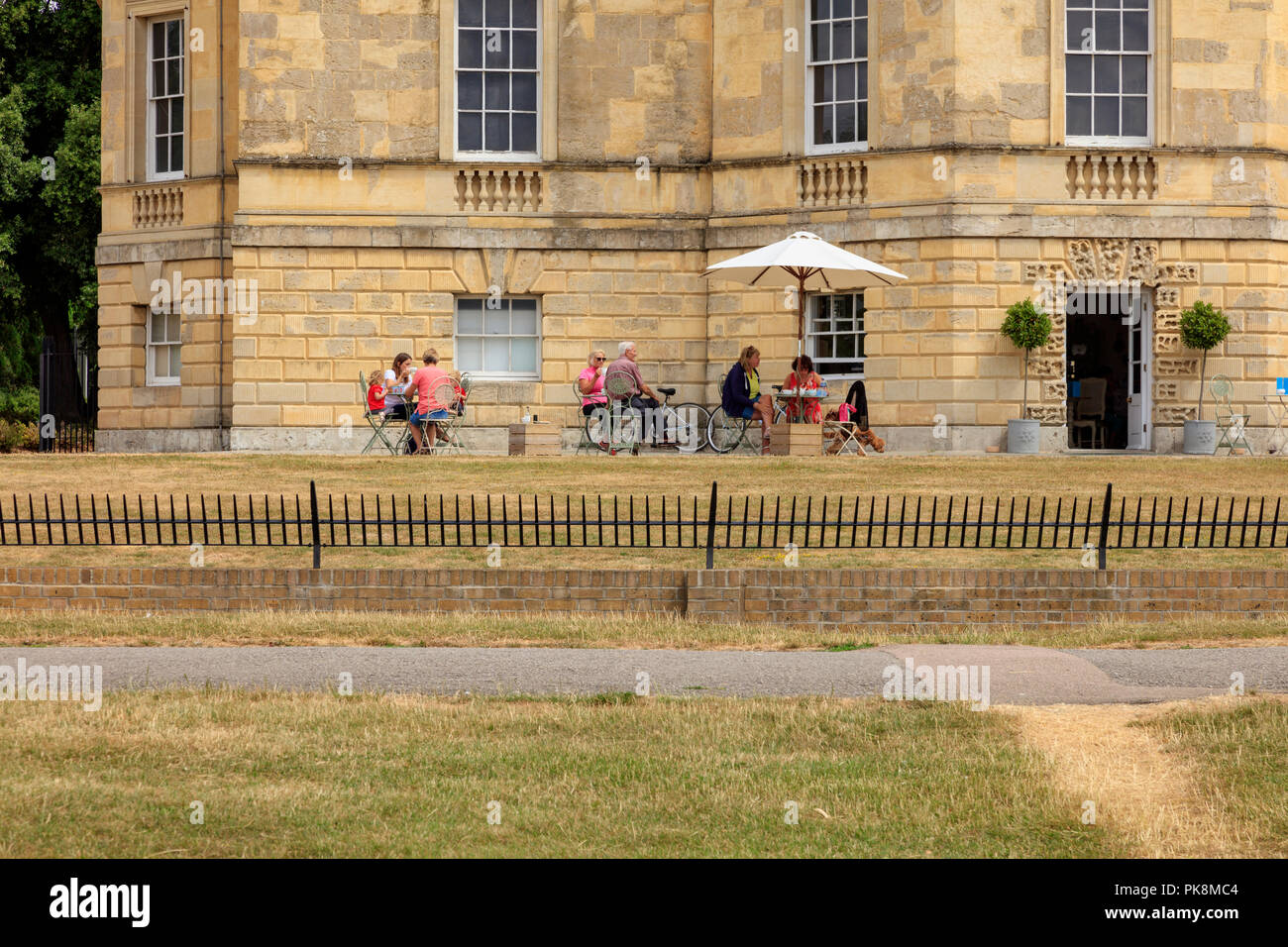 Customers sit outside a tea room in Danson House in the summer sun ...