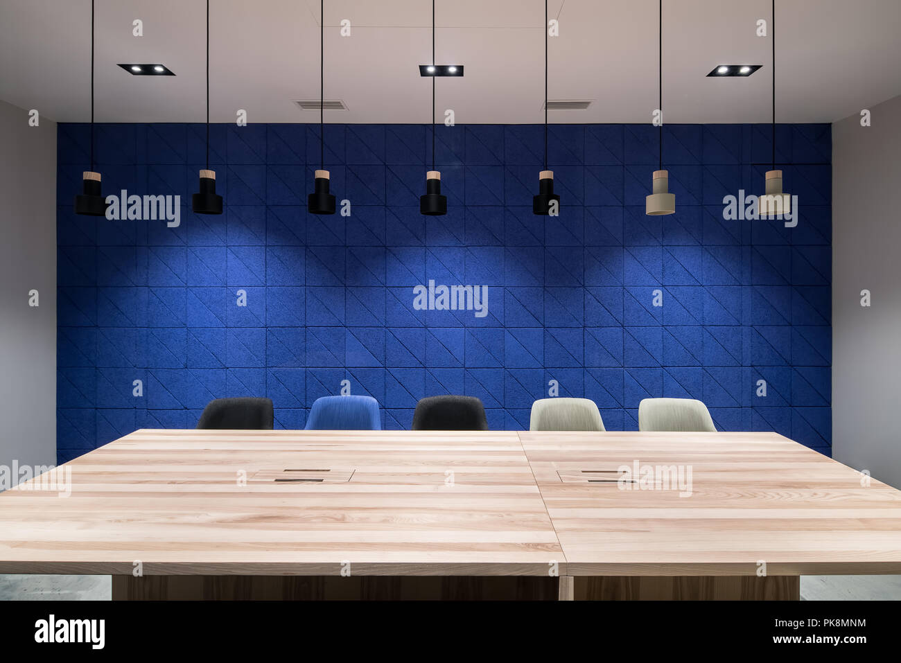 Business interior with blue wall and hanging lamps Stock Photo - Alamy