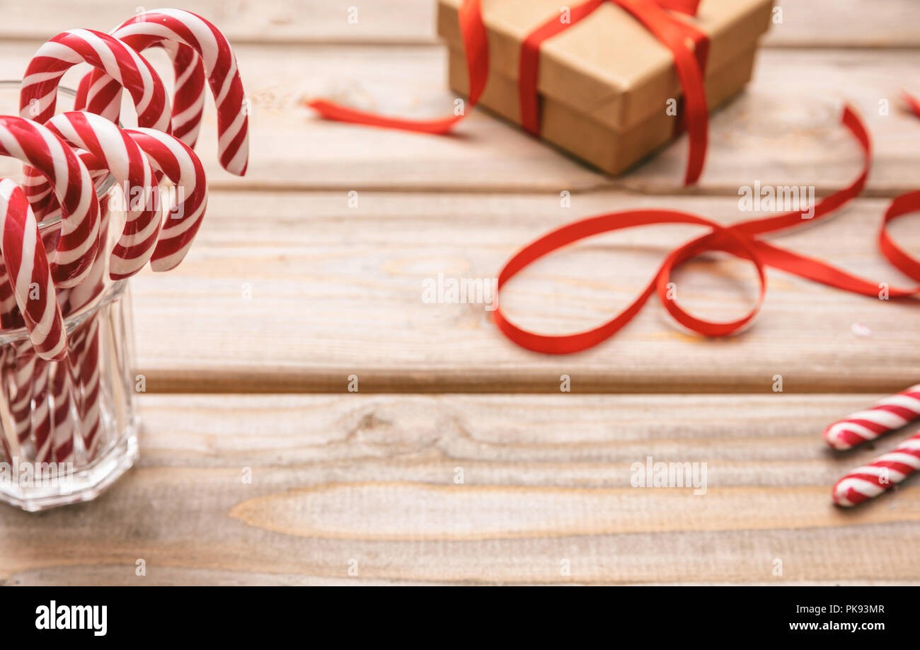 Christmas time. Candy canes in a glass, wooden background, copy space ...