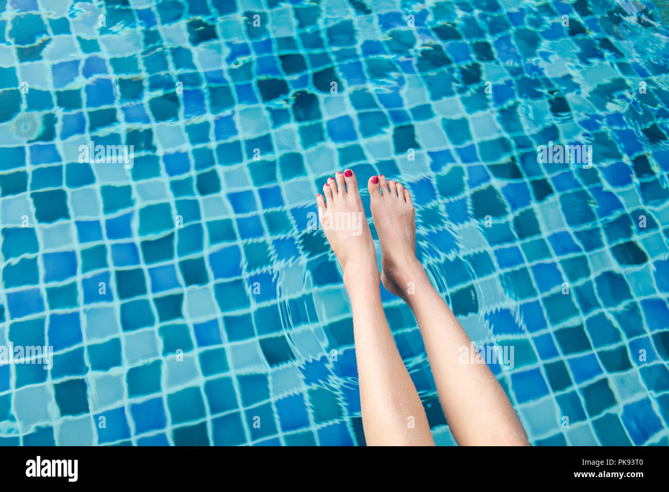 Young women sitting at swimming pool hi-res stock photography and ...
