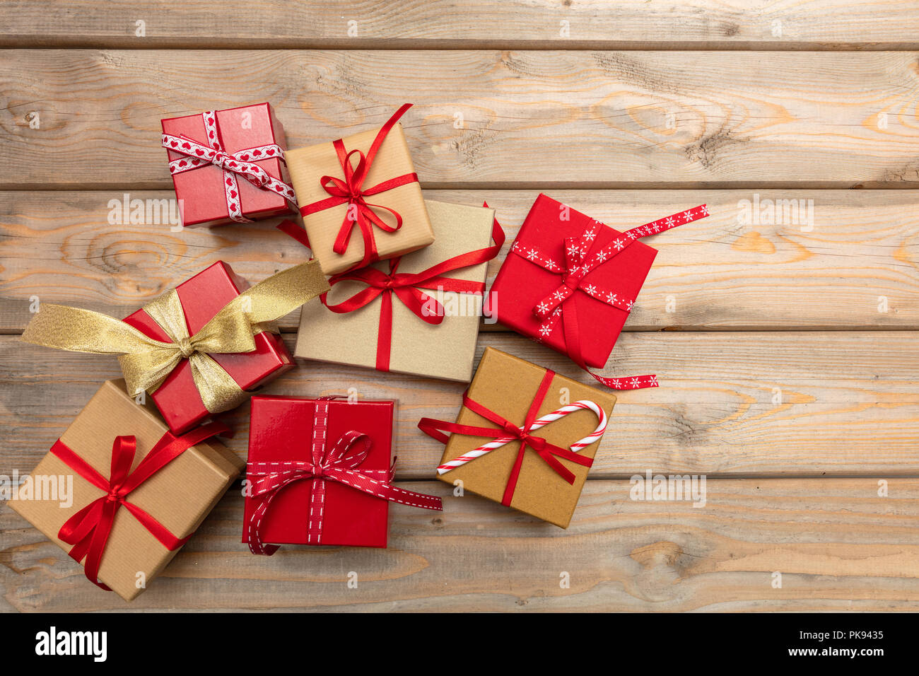 Christmas time. Gift boxes with red ribbons on wooden background, copy ...