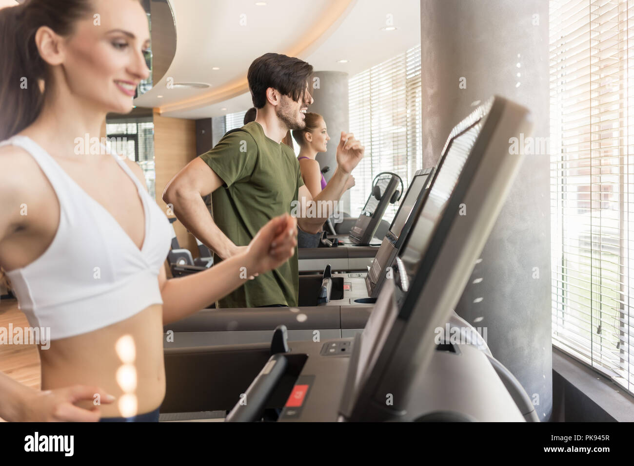Group of four people running on treadmills in fitness gym Stock Photo ...