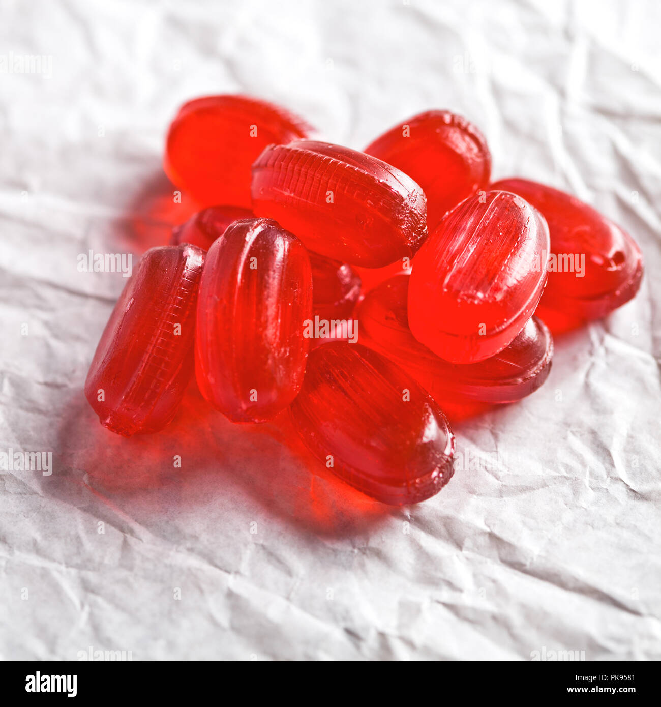 heap of red candies on paper background Stock Photo - Alamy