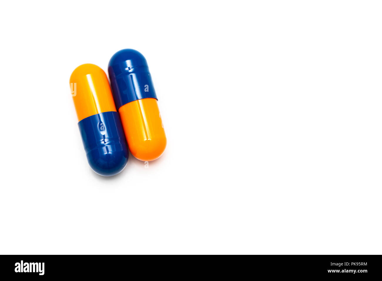 Blue & Orange drug medicine pills colored capsules closeup on white ...