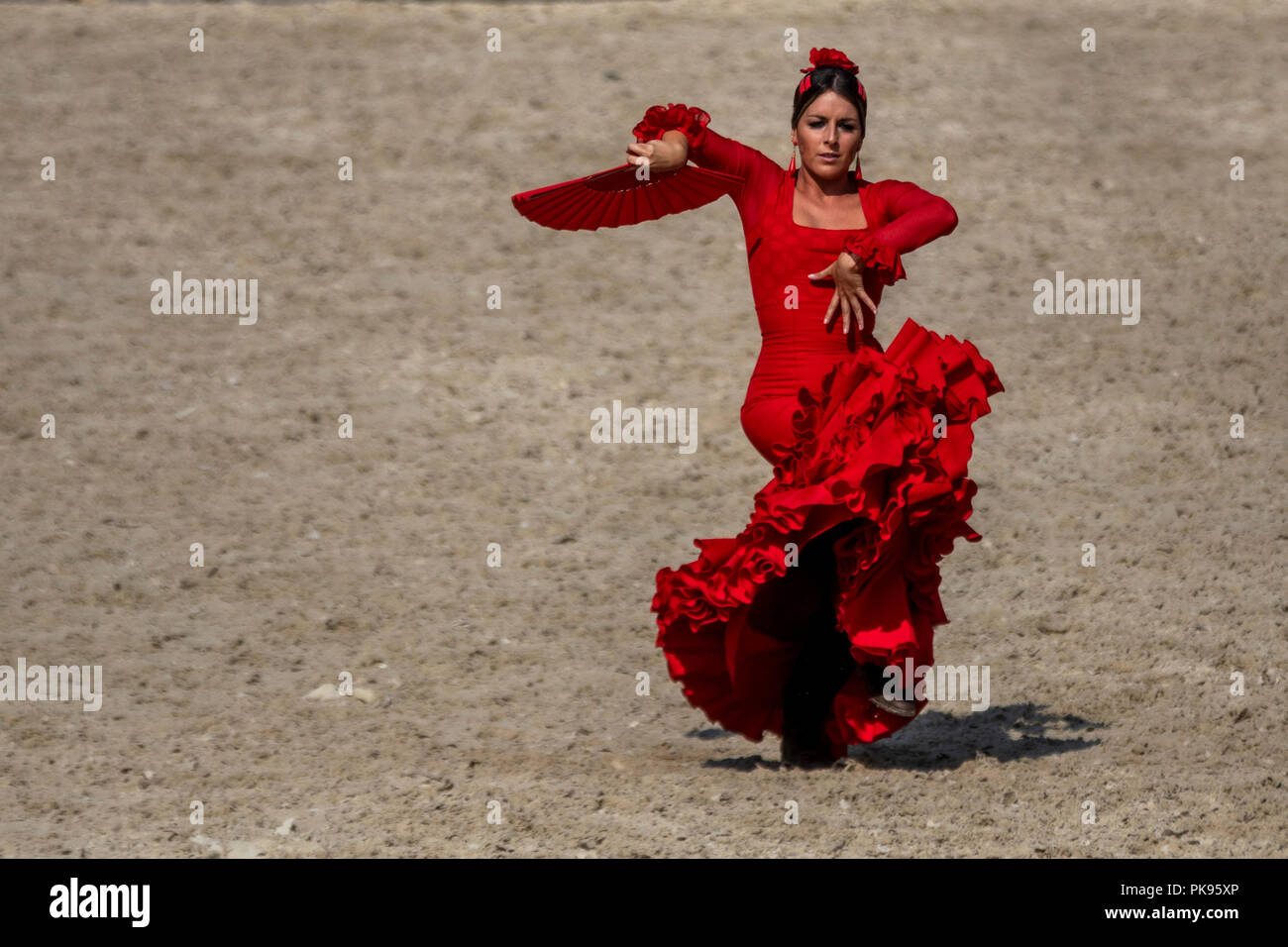 A beautiful woman performing traditional Spanish flamenco dance with a ...