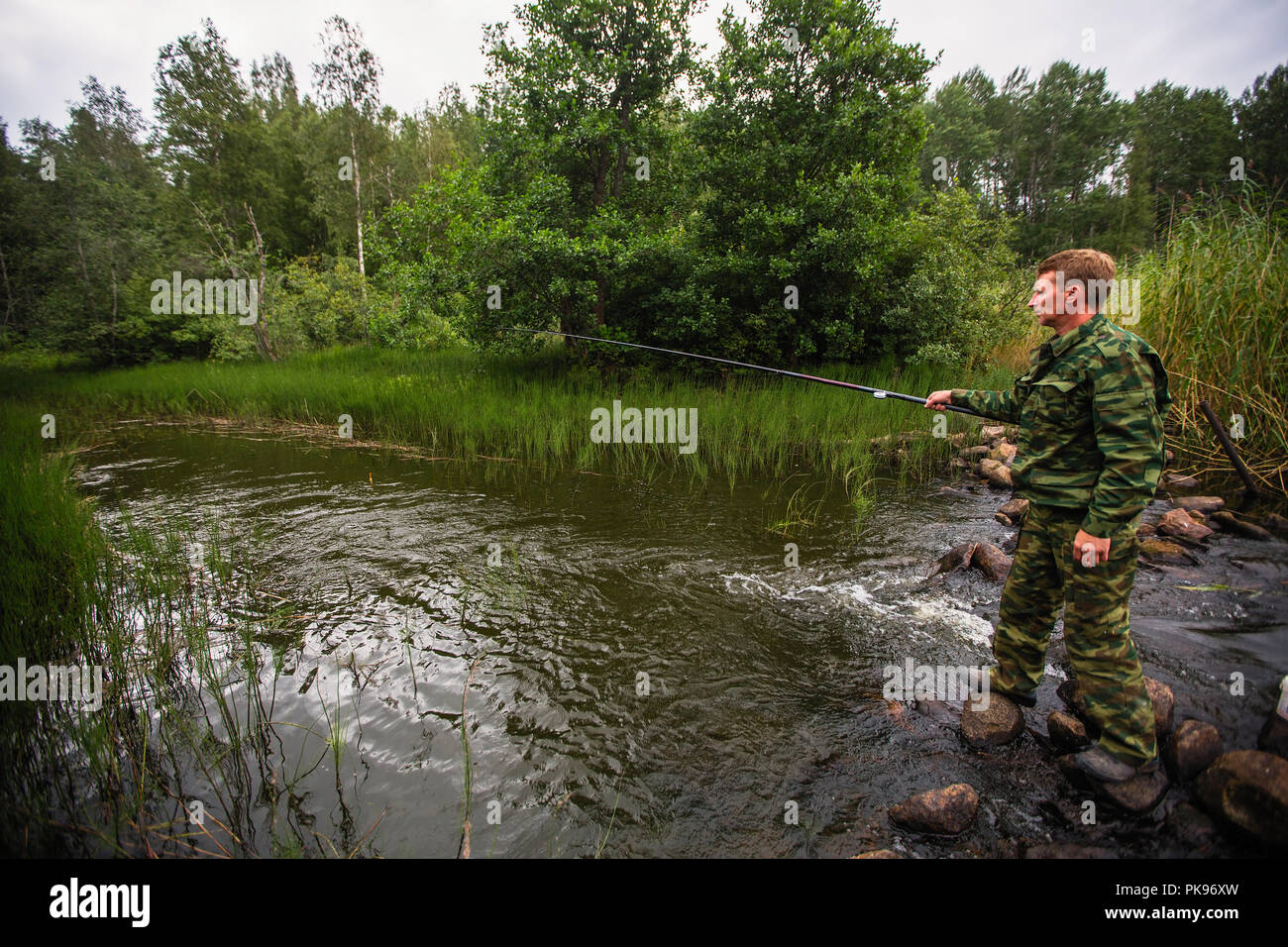 Fisherman catching fish on the river Stock Photo - Alamy