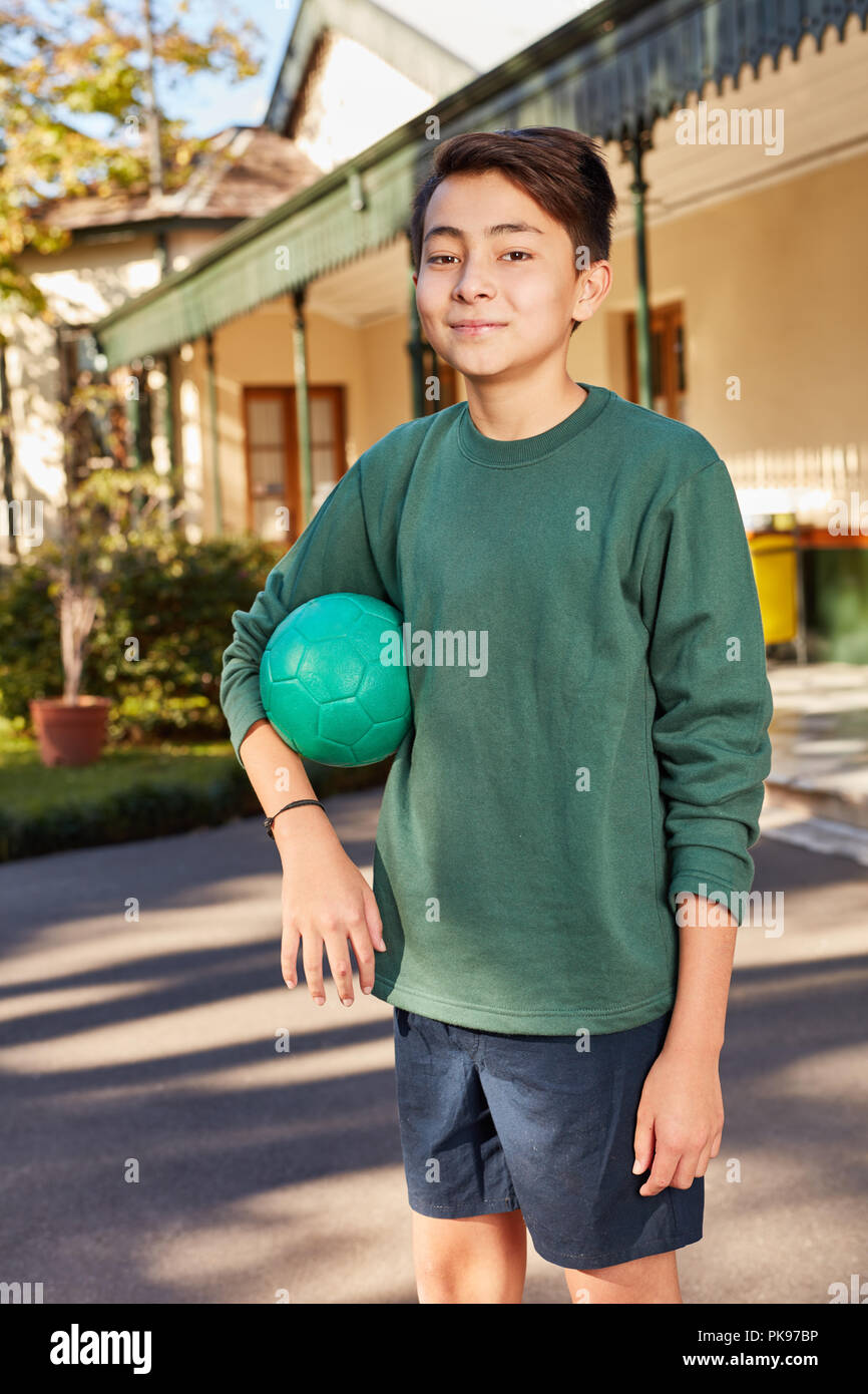 Boy at sport with a ball in summer camp or in the schoolyard Stock ...