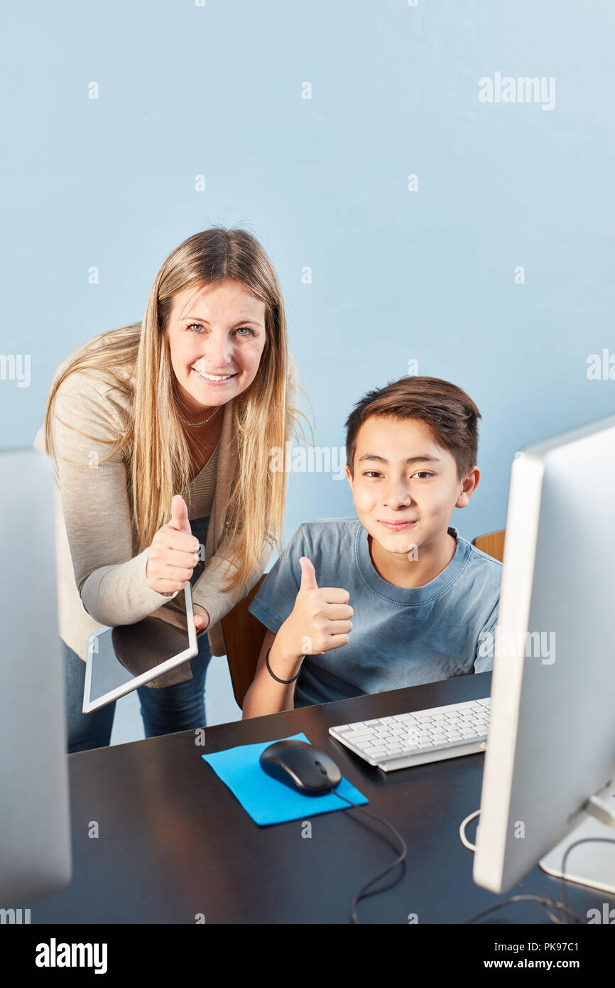 Student and teacher with thumbs up at the primary school computer Stock ...