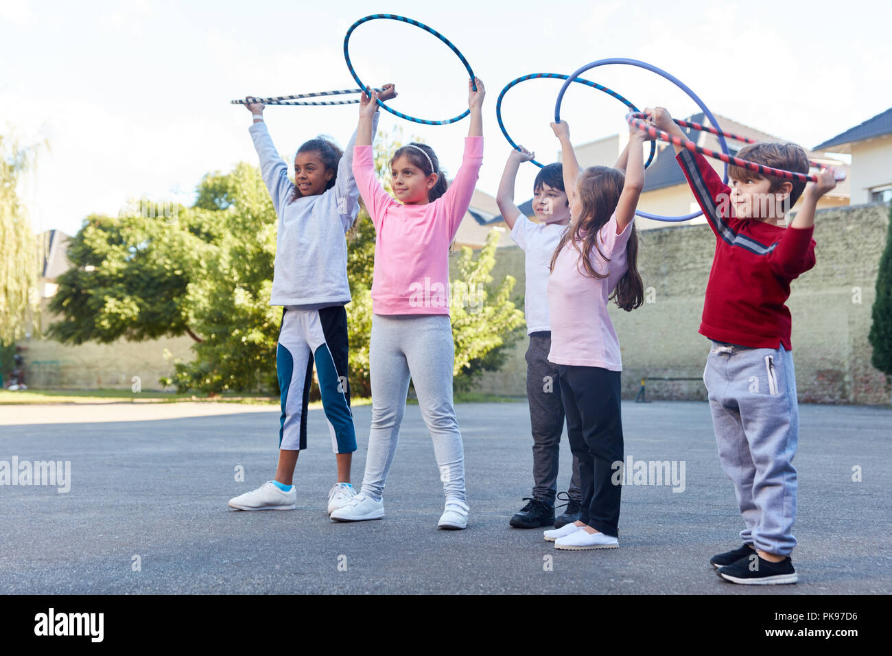 Student group is doing exercise with hoops in physical education in the ...
