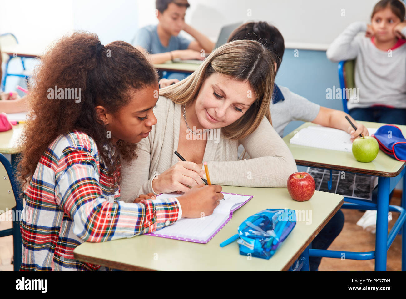 Girl gets tutoring from a teacher in elementary school or OGS Stock ...