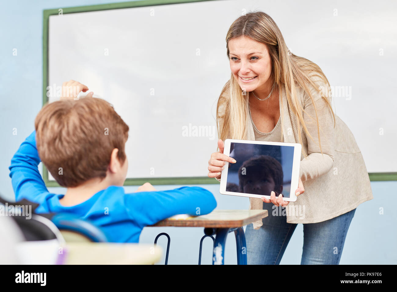 Teacher with tablet PC teaches a student in computer science class ...