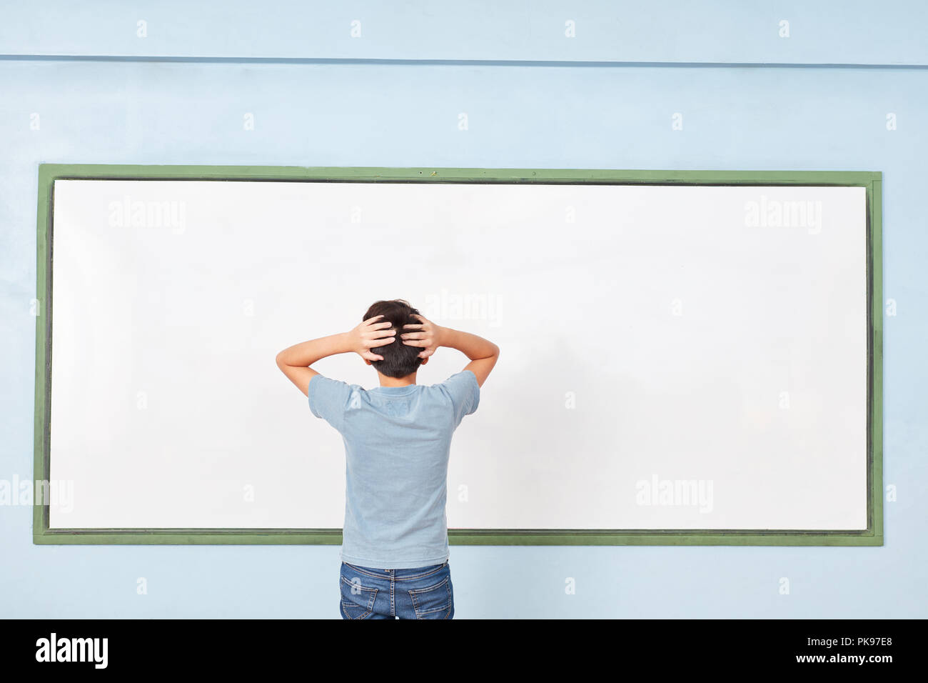 Pupil stands in front of a blackboard thinking about a difficult ...