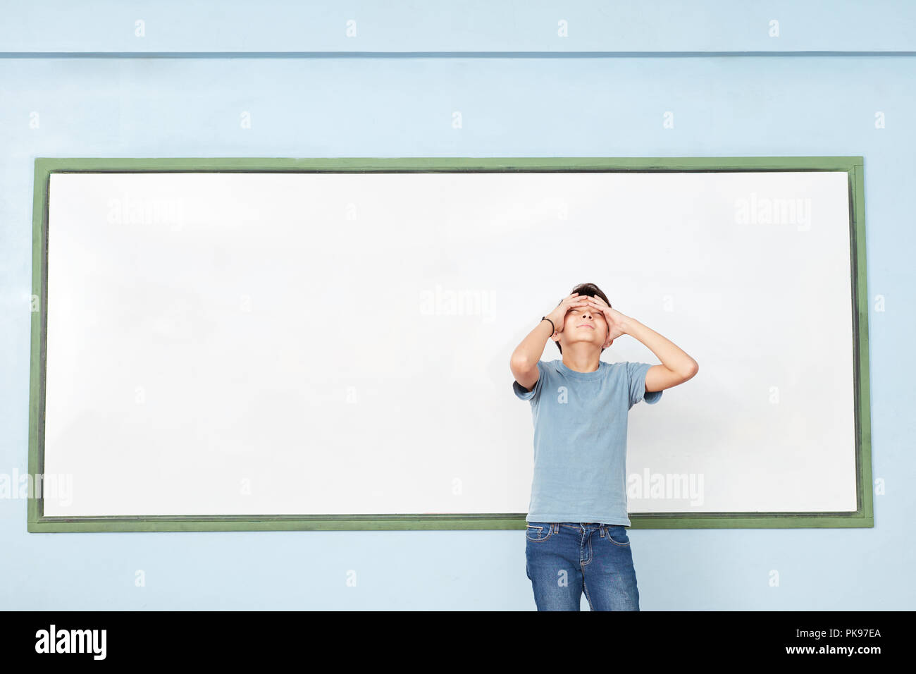 Pupil in an exam at the whiteboard reflects concentrated on solution ...
