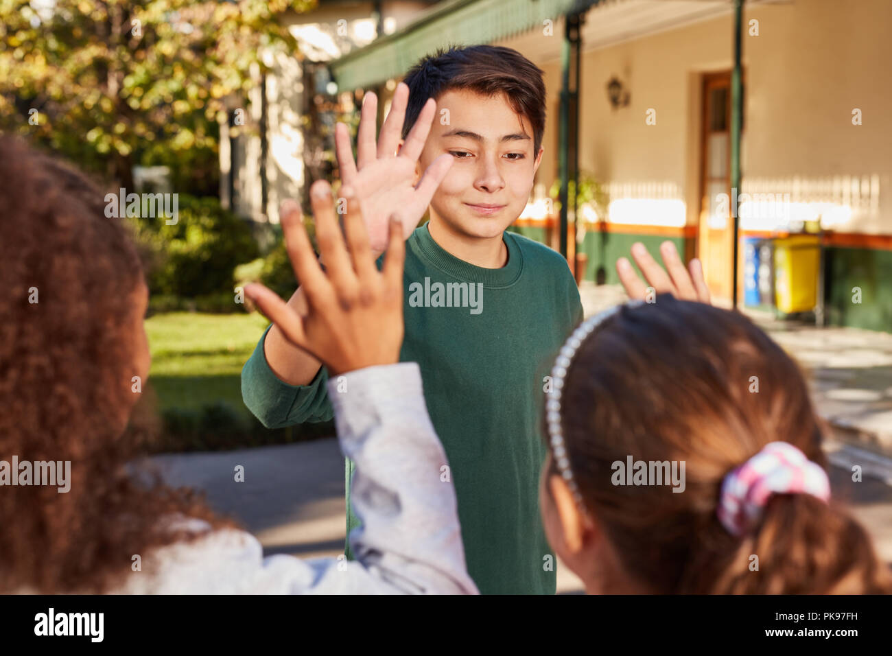 Group of children gives themselves a high five as a team in physical ...