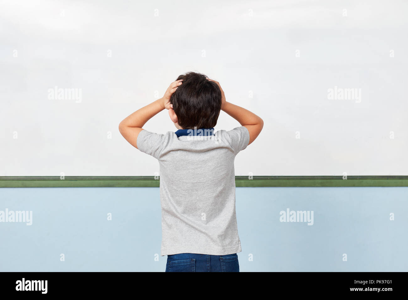 Desperate student is in a difficult exam in front of the blackboard ...