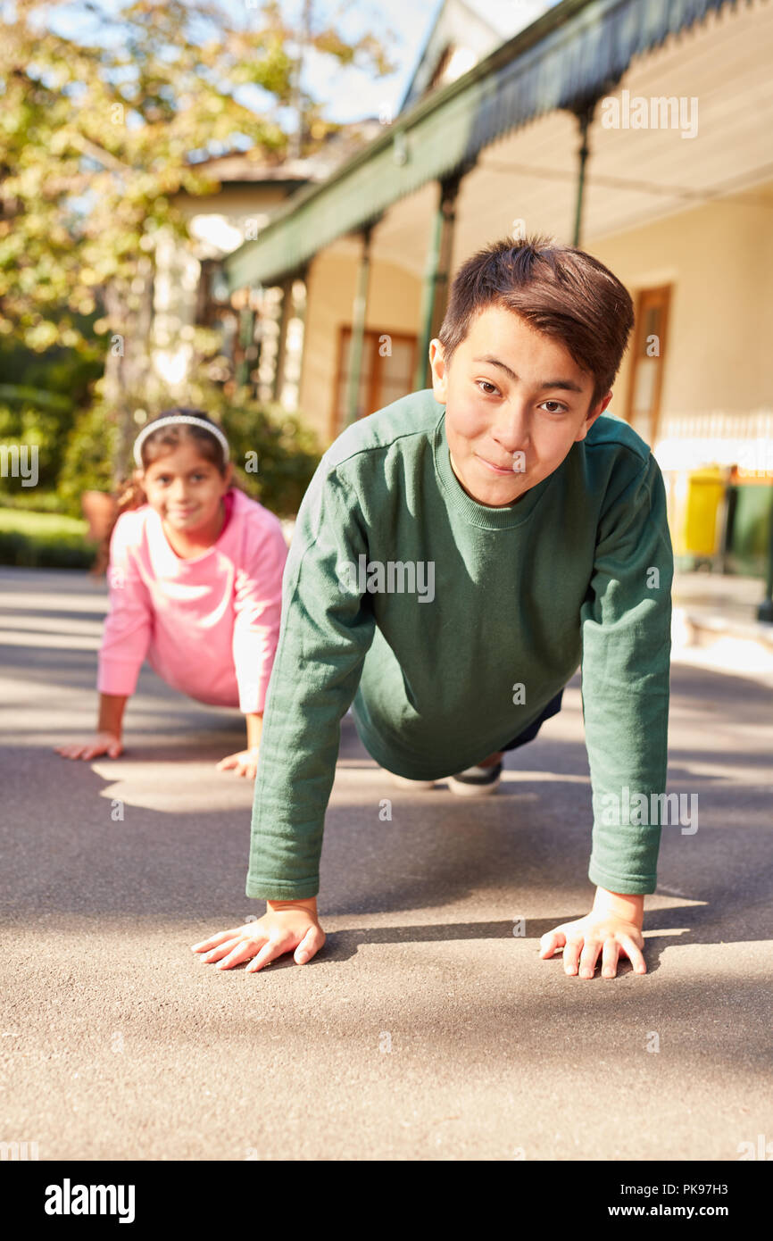 Boy as a student doing push-ups in school physical education Stock ...