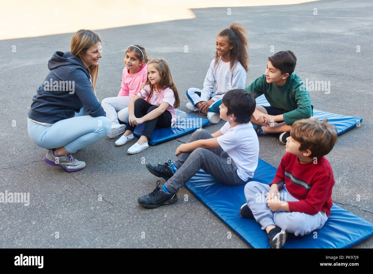 Sports teacher and group of students in physical education or at camp ...