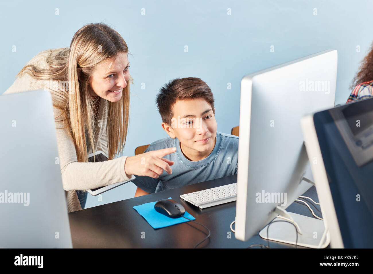 Teacher helps a student to learn at the computer in school Stock Photo ...