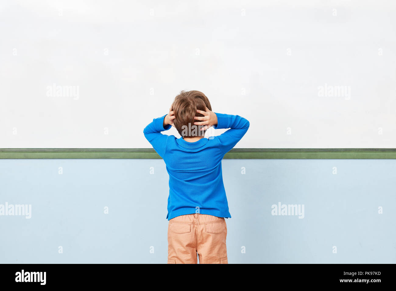 Pupil in an exam at the blackboard is thinking about a difficult task ...