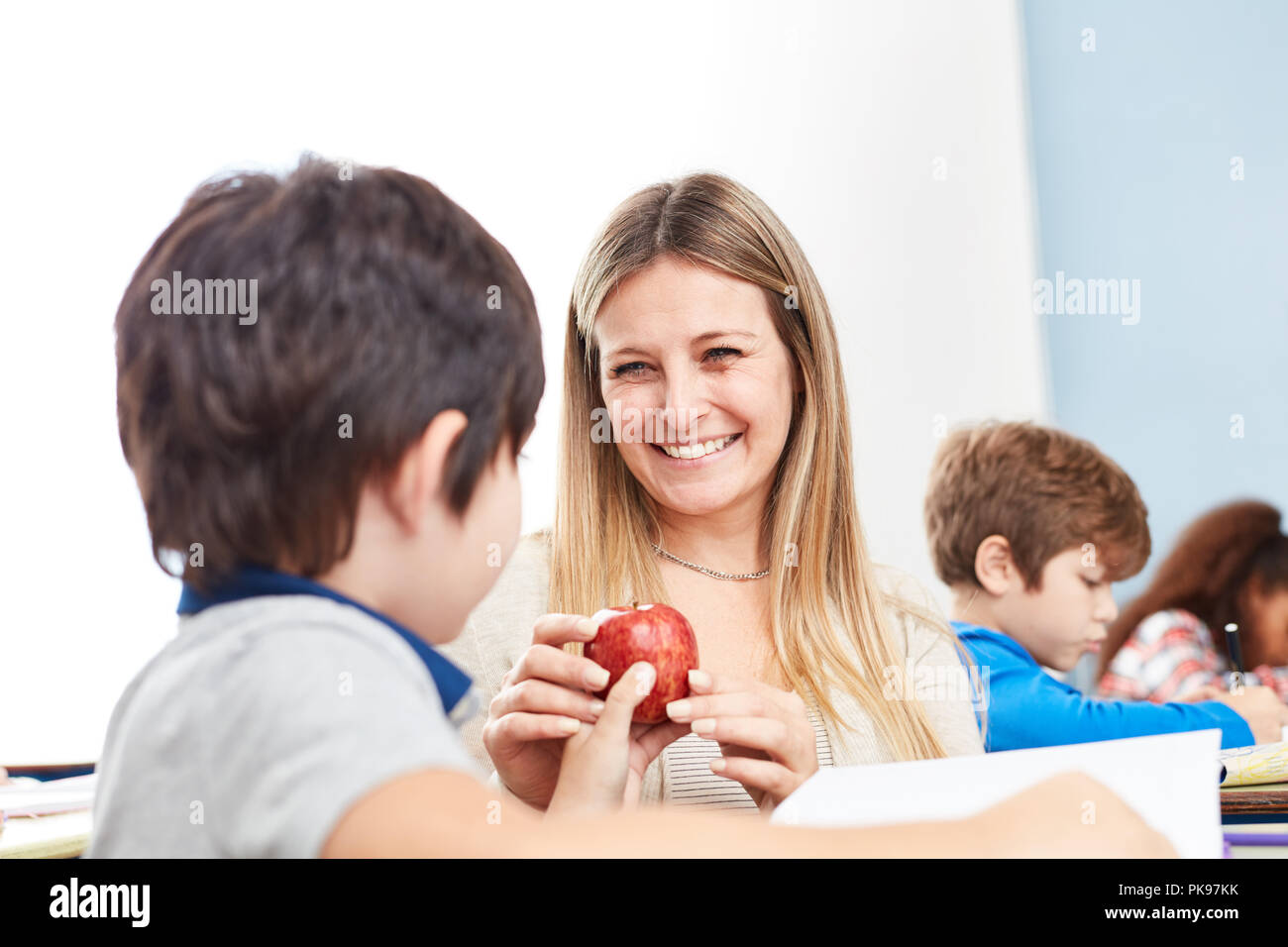 Student gives an apprentice an apple in elementary school to his tutor ...