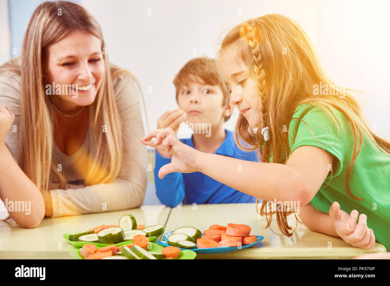 Children eat vegetables together as a snack during breaks from primary ...