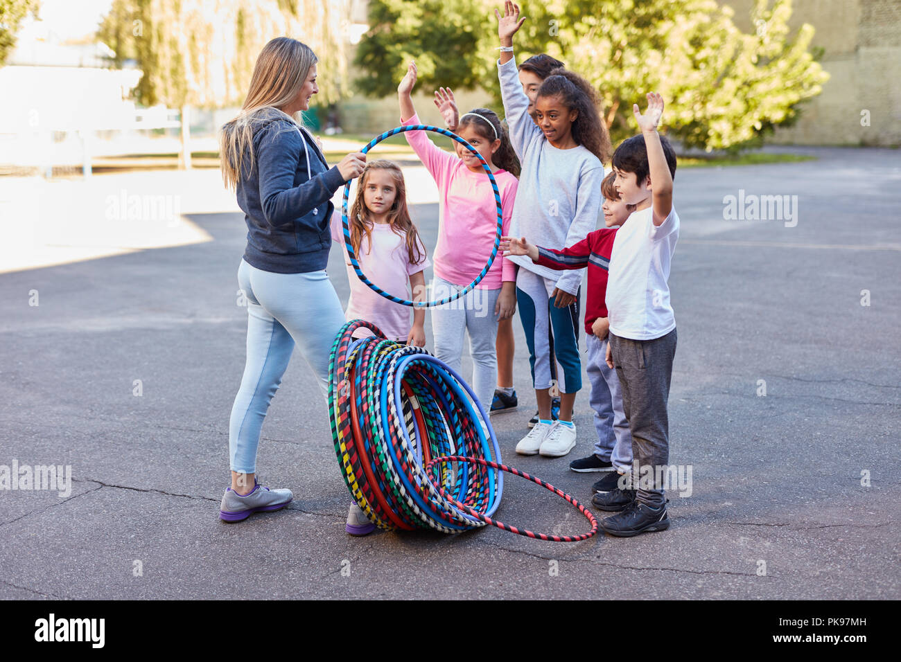 Group of kids and teachers in physical education with hoops in the ...