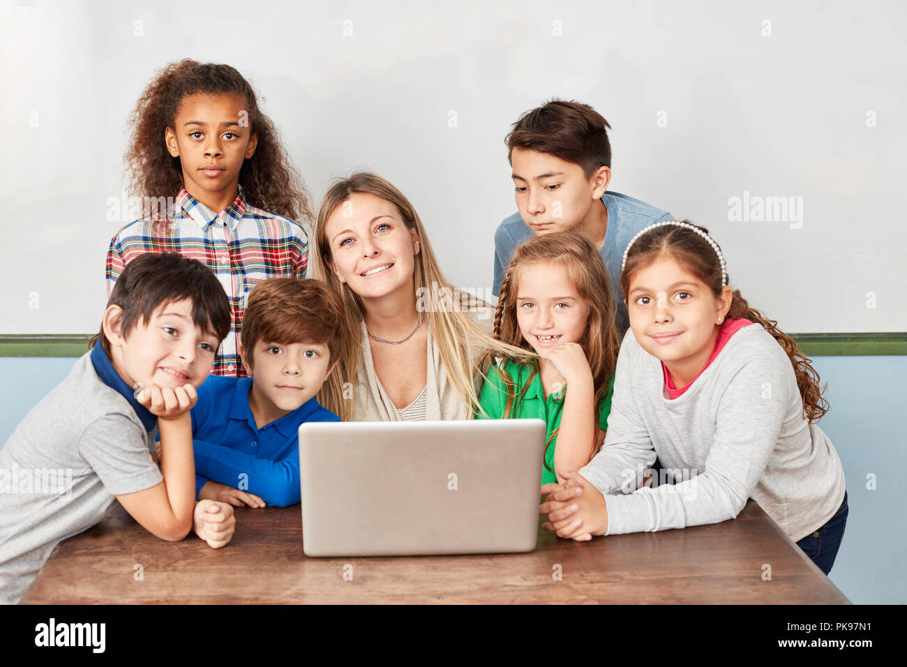 Elementary school students and teacher learn together at the laptop PC ...