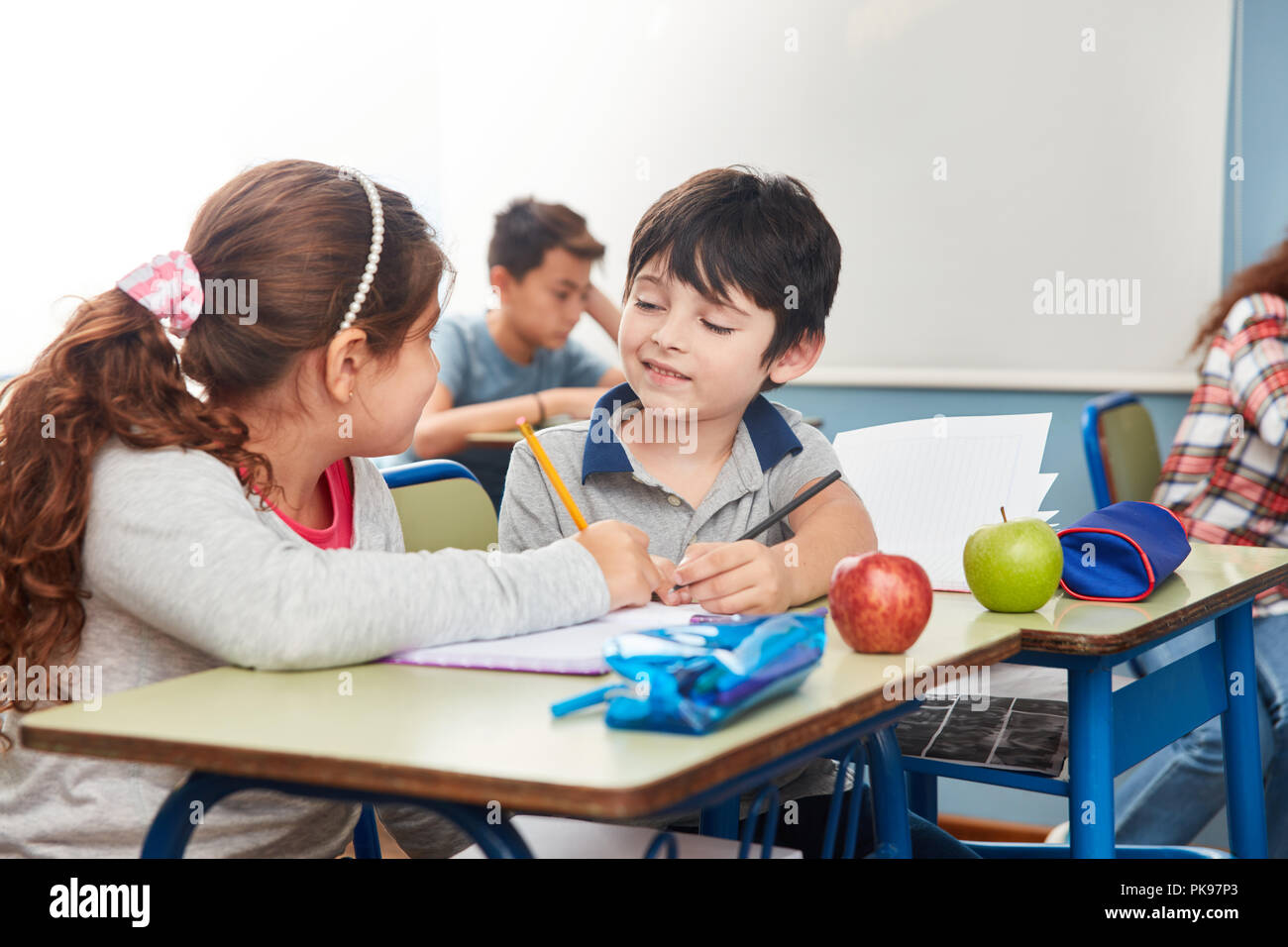 Two children help themselves while learning in primary school lessons ...