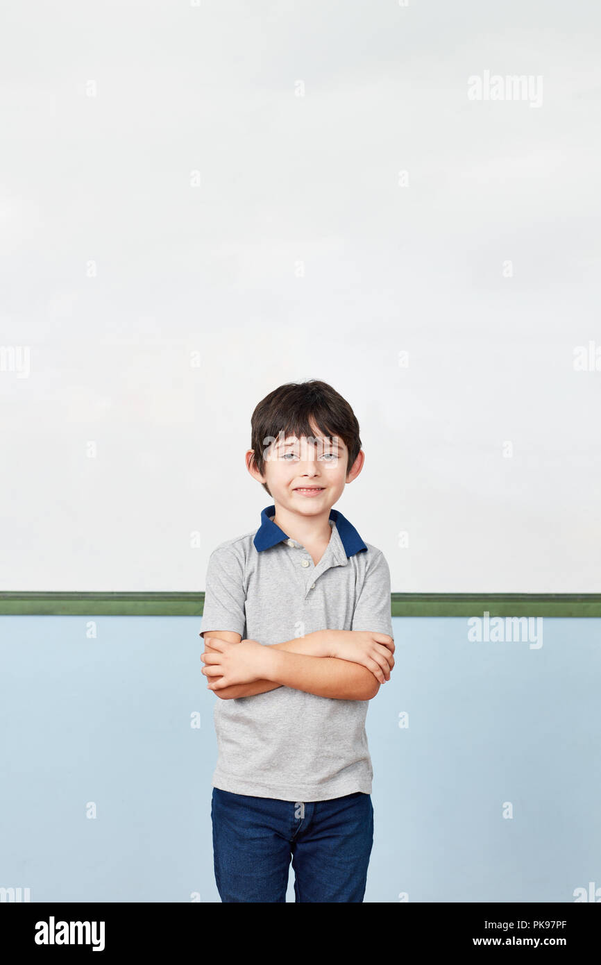 Proud boy as a student in elementary school with crossed arms Stock ...