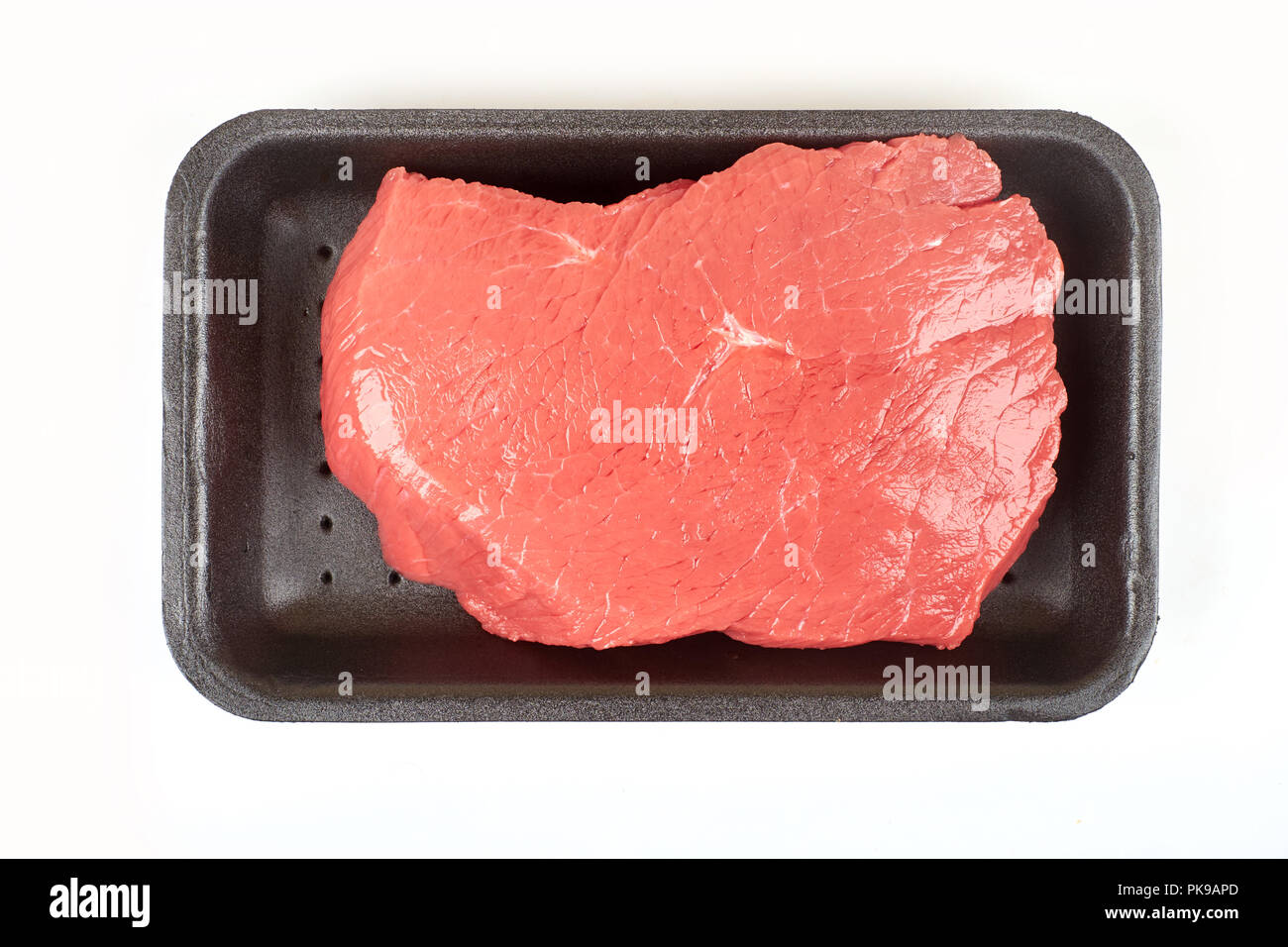 Big red meat chunk in package, on white background Stock Photo - Alamy