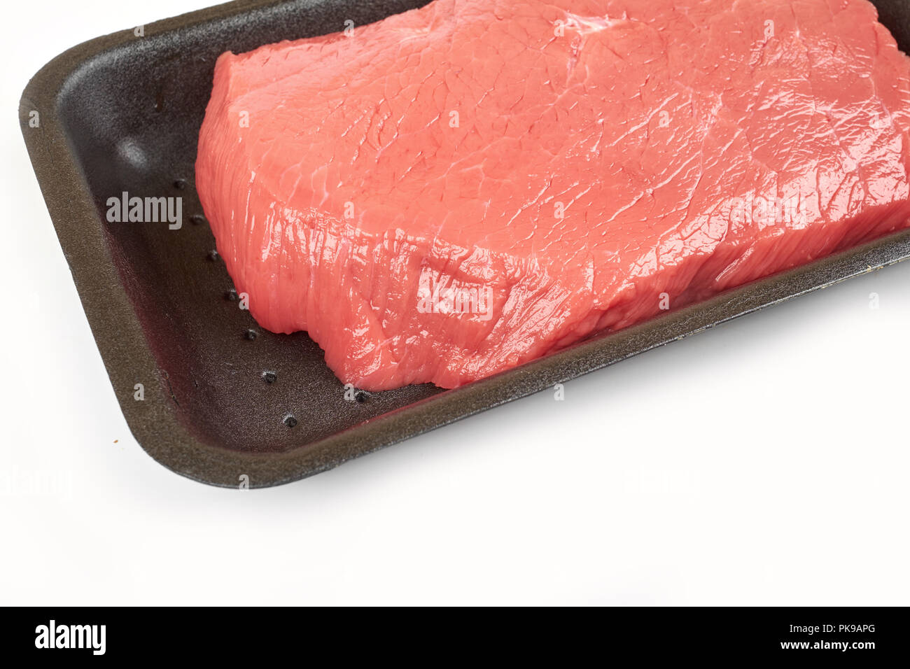 Big red meat chunk in package, on white background Stock Photo - Alamy