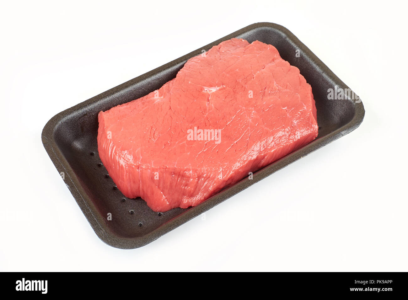 Big red meat chunk in package, on white background Stock Photo - Alamy