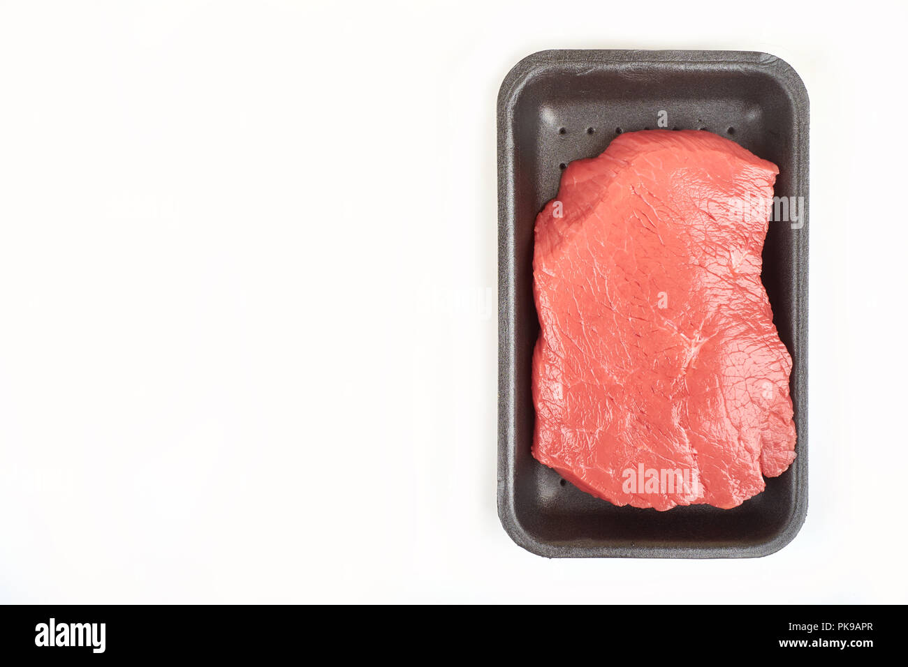 Big red meat chunk in package, on white background Stock Photo - Alamy