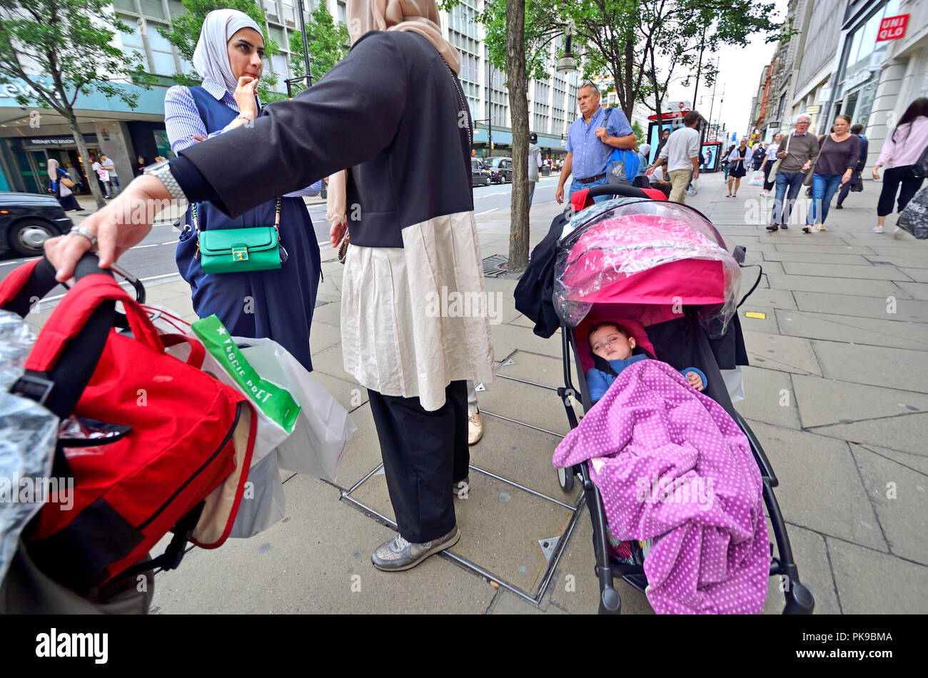 Muslim women with a child asleep in a pushchair, Oxford Street, London ...